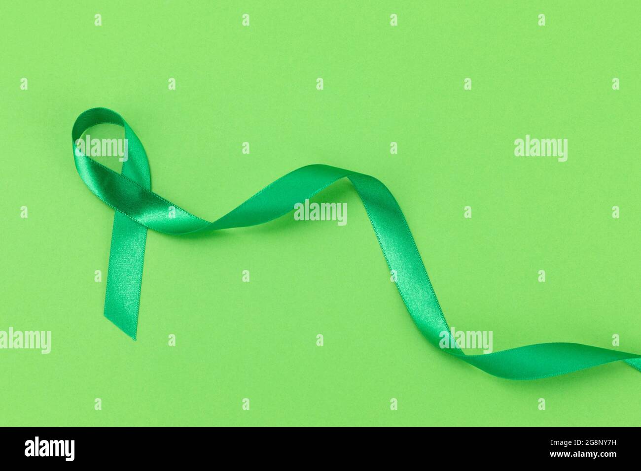 green ribbon on green background Stock Photo - Alamy