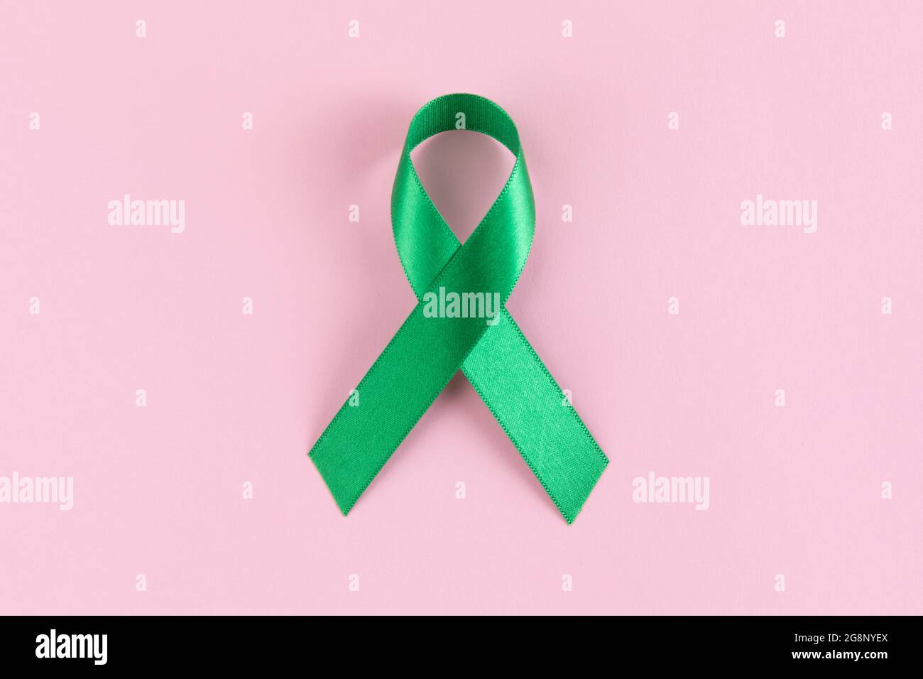 green ribbon on pink background Stock Photo - Alamy