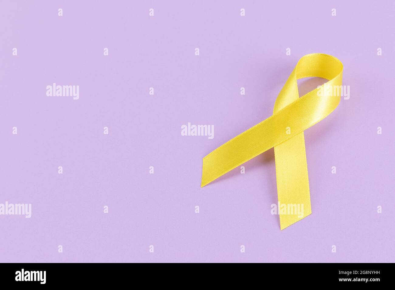 Yellow ribbon on purple background Stock Photo - Alamy