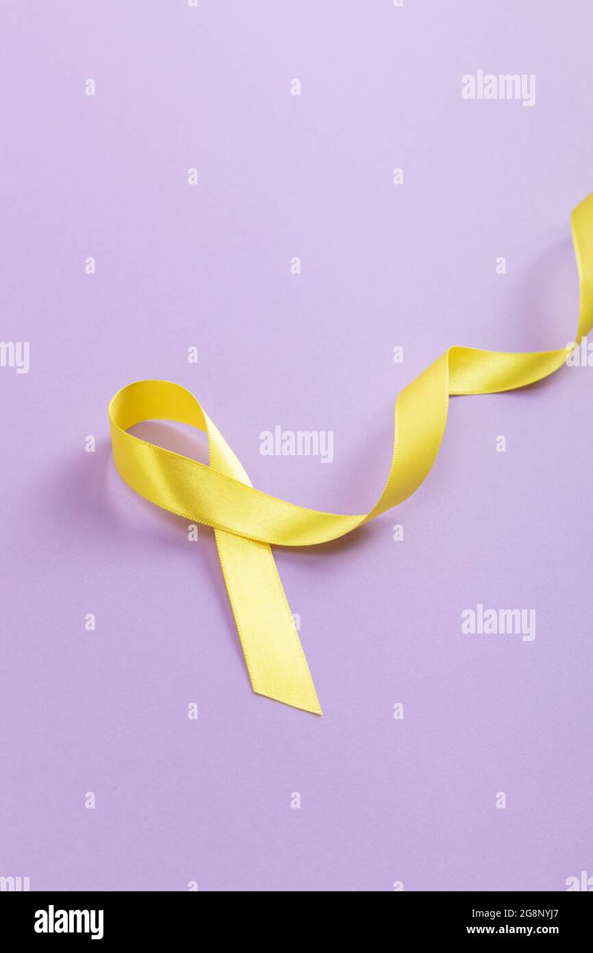 Yellow ribbon on purple background Stock Photo - Alamy