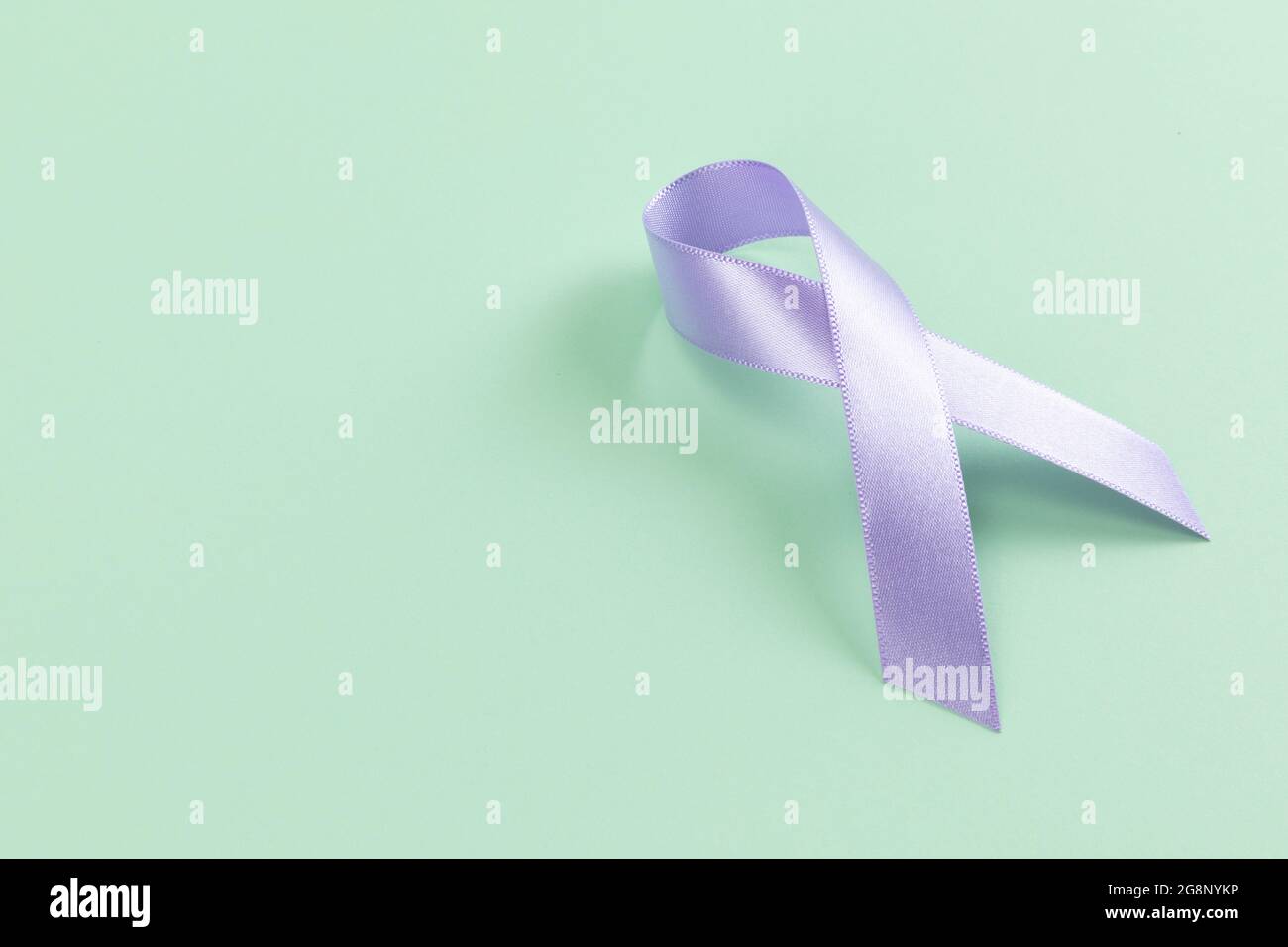 purple ribbon on mint color background Stock Photo - Alamy