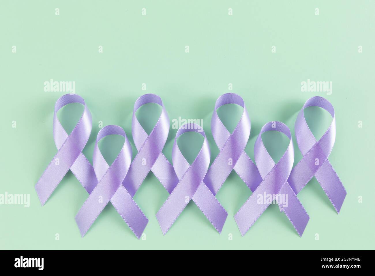 purple ribbon on mint color background Stock Photo - Alamy