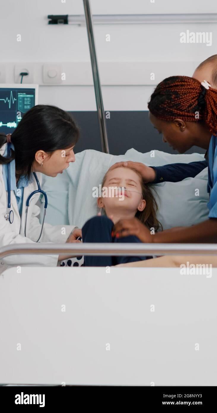 Pediatrician woman doctor holding sick little child monitoring disease ...