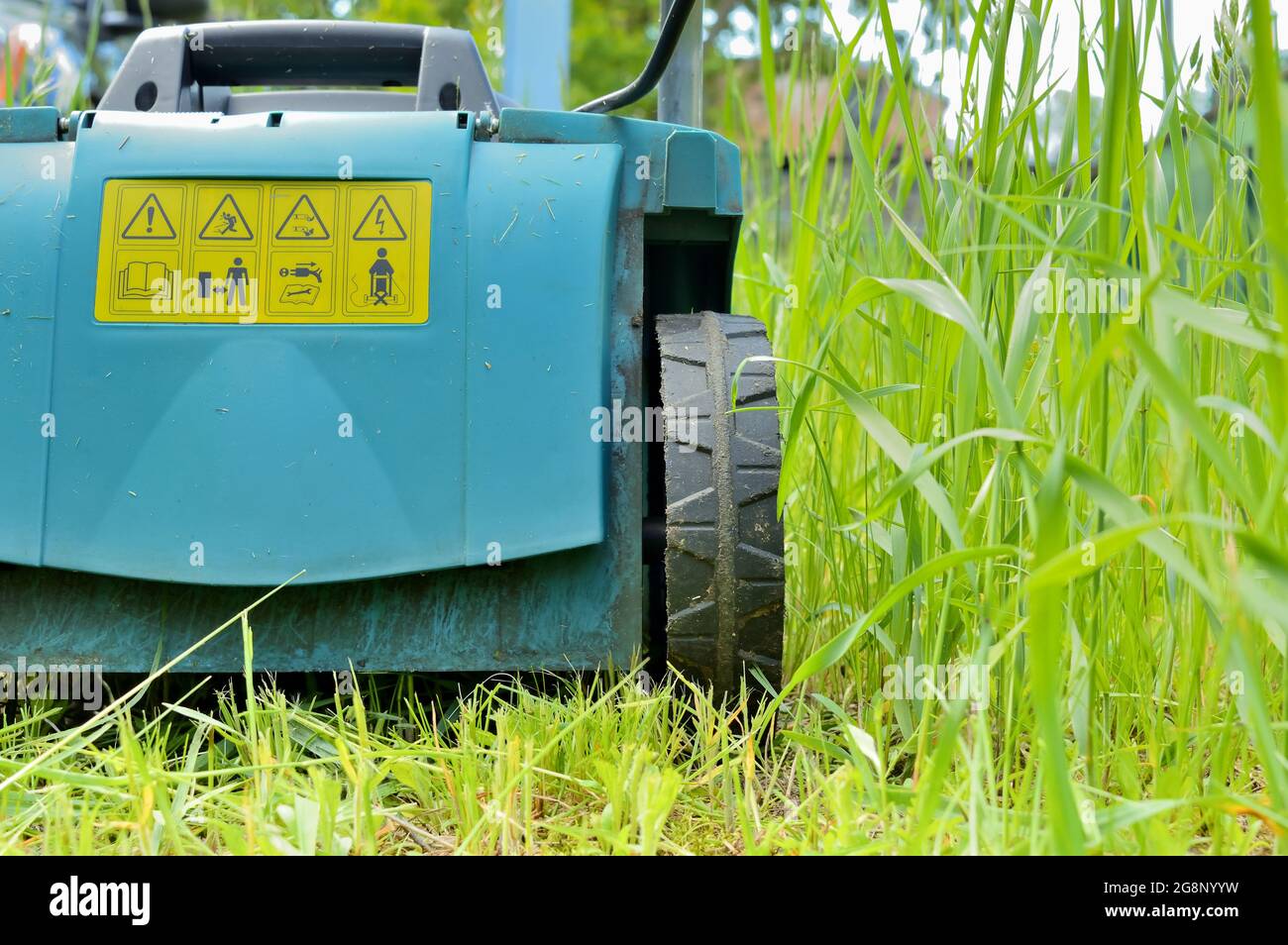 backside of electric lawn mower with safety and danger signs and icons ...