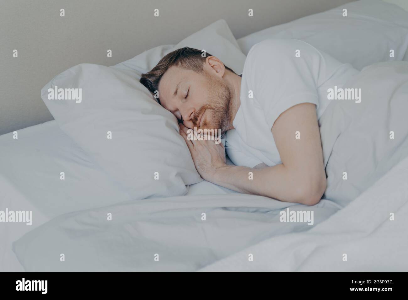 Handsome young man comfortably sleeping in bed at home Stock Photo - Alamy