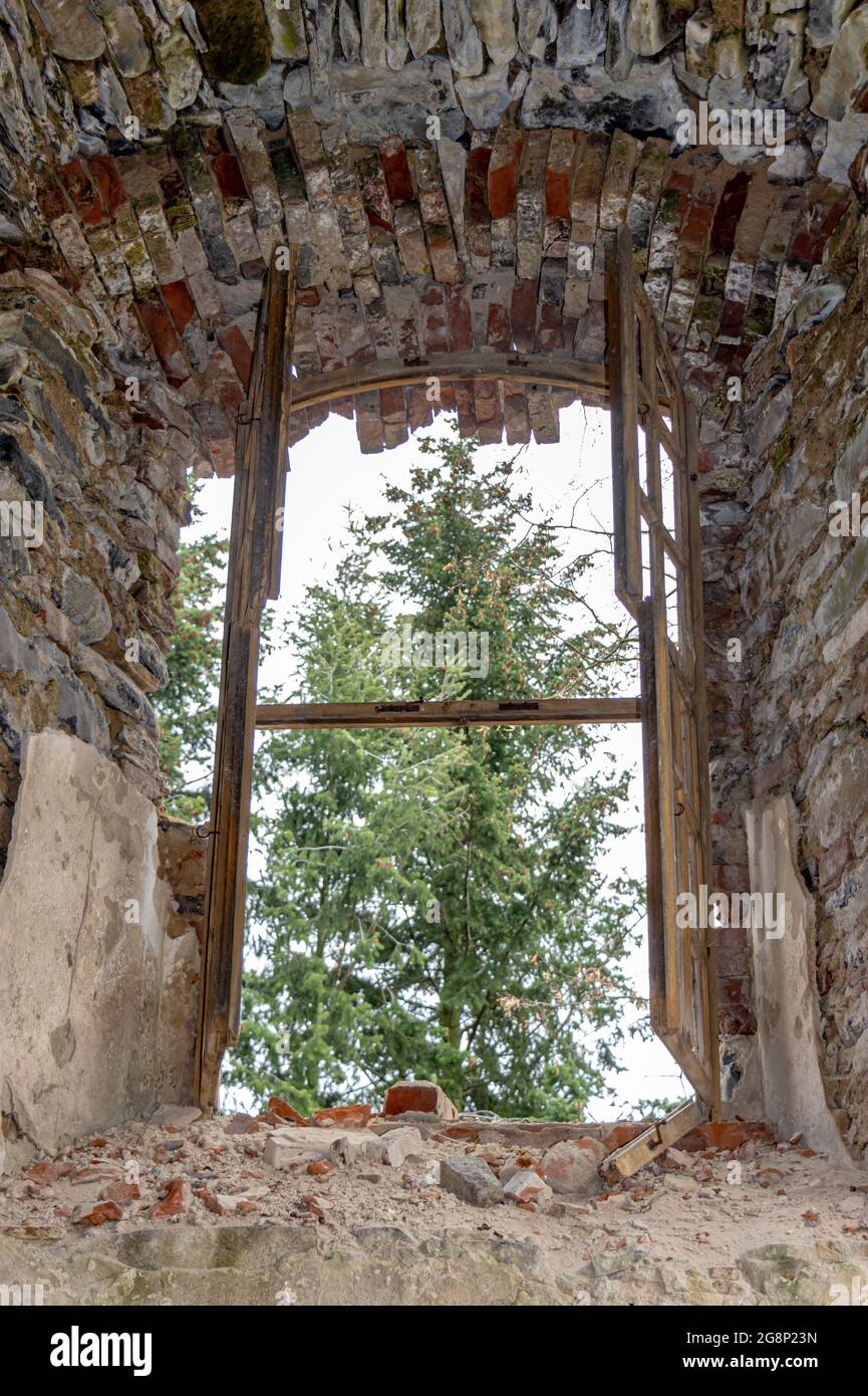View through a damaged window in an abandoned ruin in the woods Stock ...