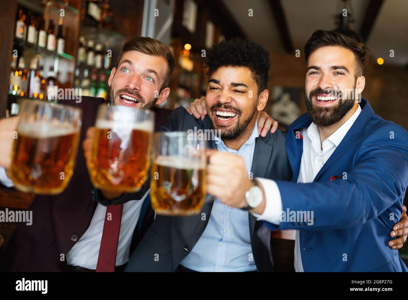 Young businessmen are drinking beer, talking and smiling while resting ...
