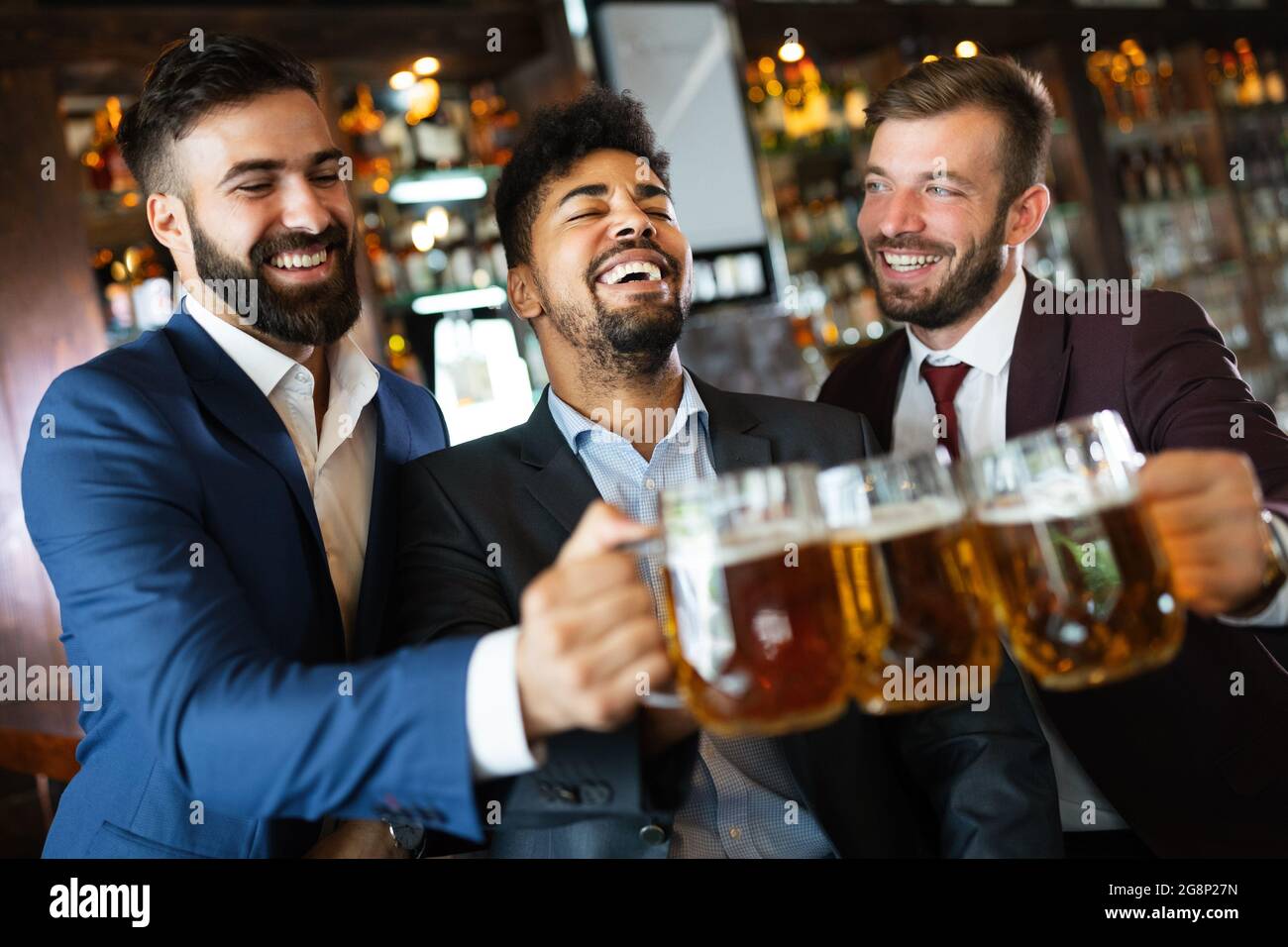 Team of colleagues socializing at the bar and drinking beers Stock ...