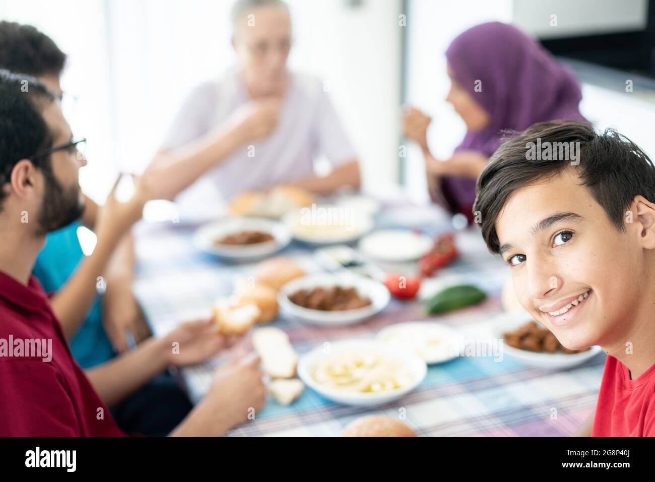 Happy family enjoying eating food in dining room Stock Photo - Alamy