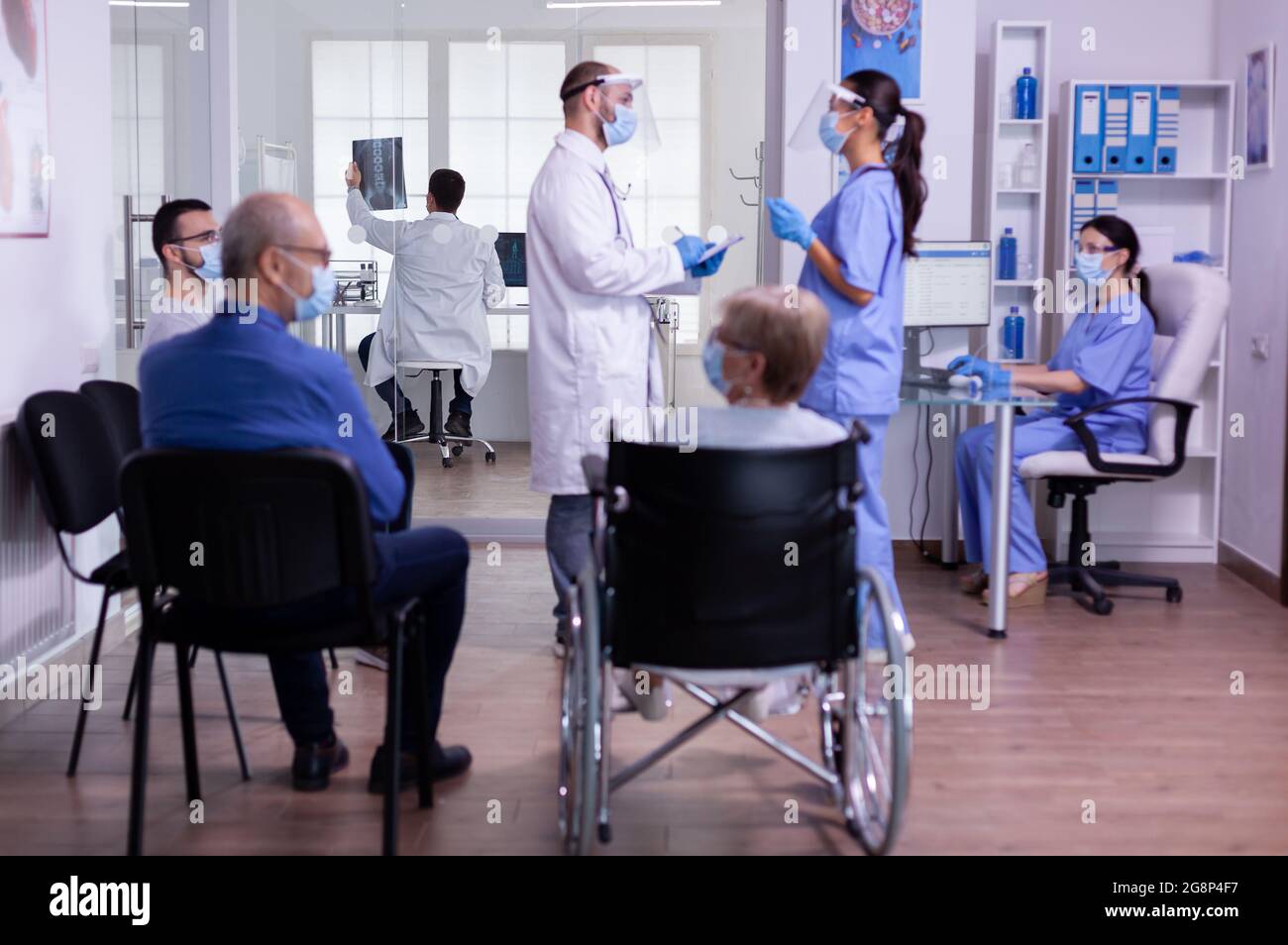 Medical team with visor and protection mask discussing standing in ...