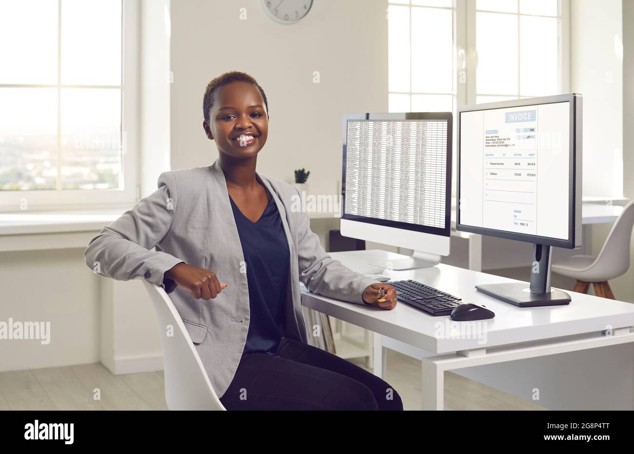 Happy black businesswoman or accountant sitting at office desk with ...
