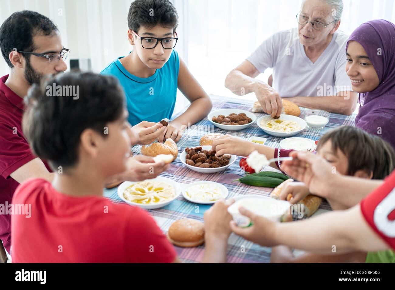 Happy family enjoying eating food in dining room Stock Photo - Alamy