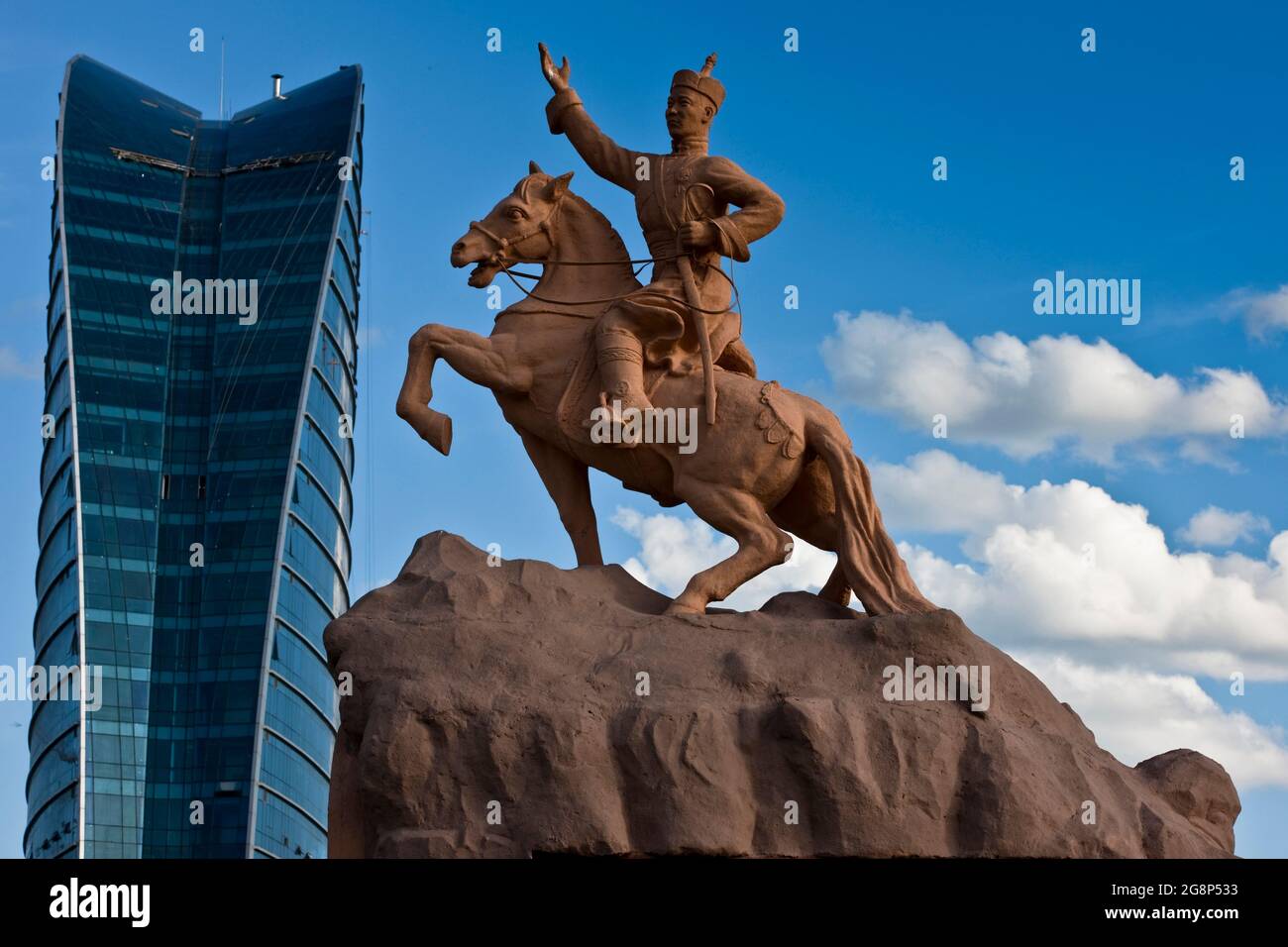 Statue of Sukhbaatar on horse, with new development behind, blue sky ...