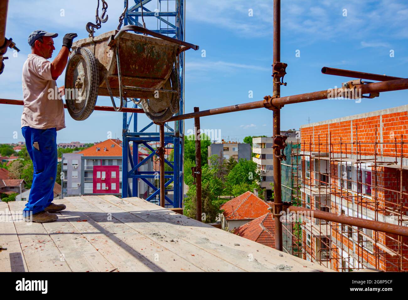 Silhouette of worker until is helping crane to keep balance and ...