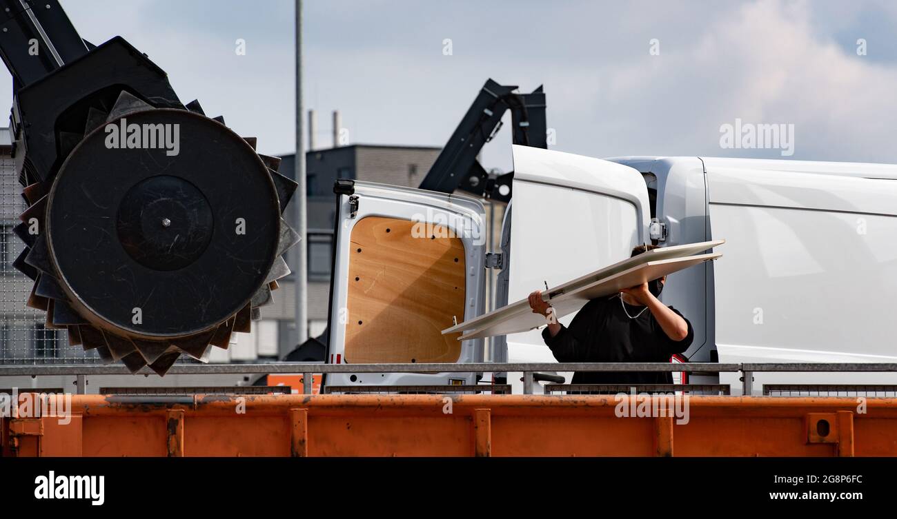 Berlin, Germany. 22nd July, 2021. A man throws slabs into a container ...
