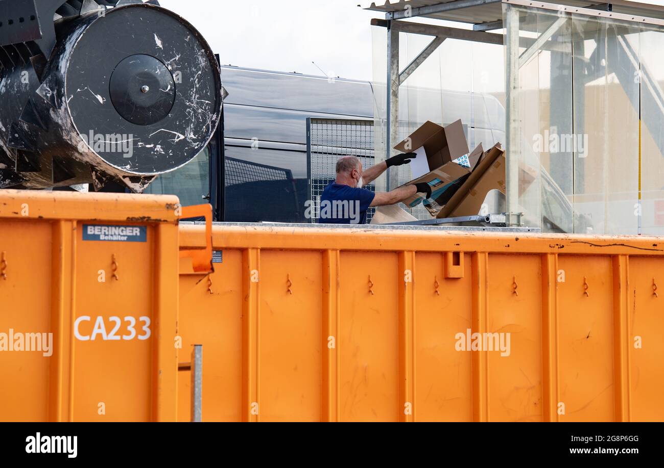 Berlin, Germany. 22nd July, 2021. A man throws cardboard boxes into a ...
