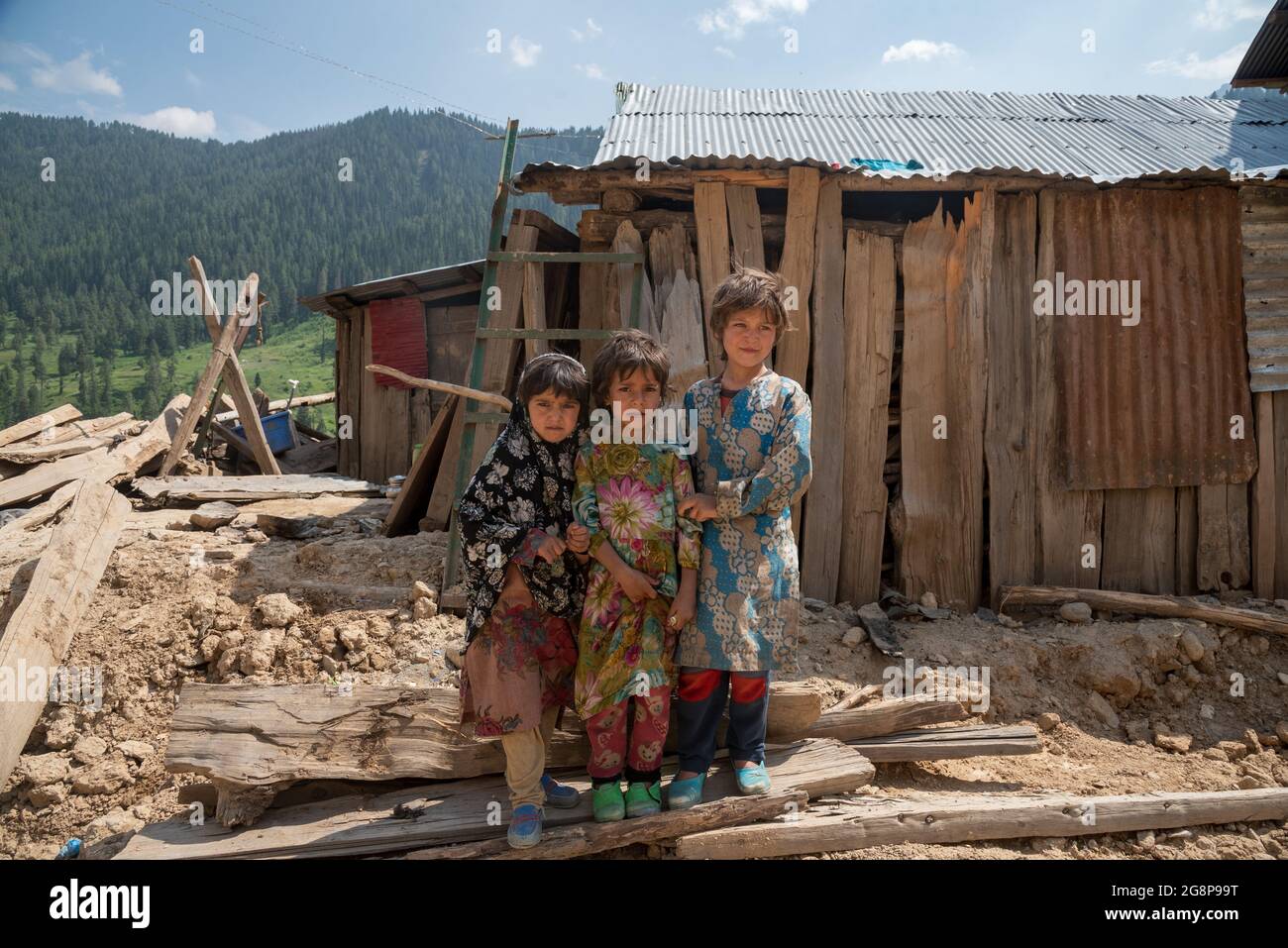 Girls from Dard tribe pose for a picture outside their home in Tulail ...