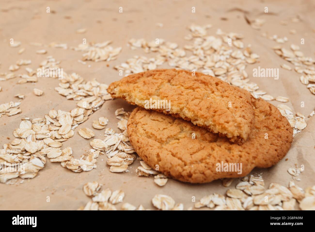 oatmeal cookies and scattered oatmeal on crumpled paper background ...