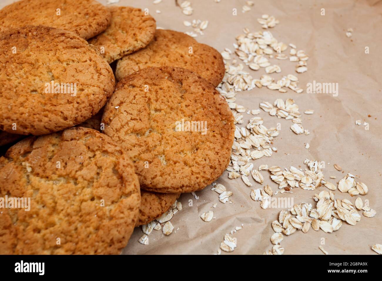 oatmeal cookies and scattered oatmeal on crumpled paper background ...