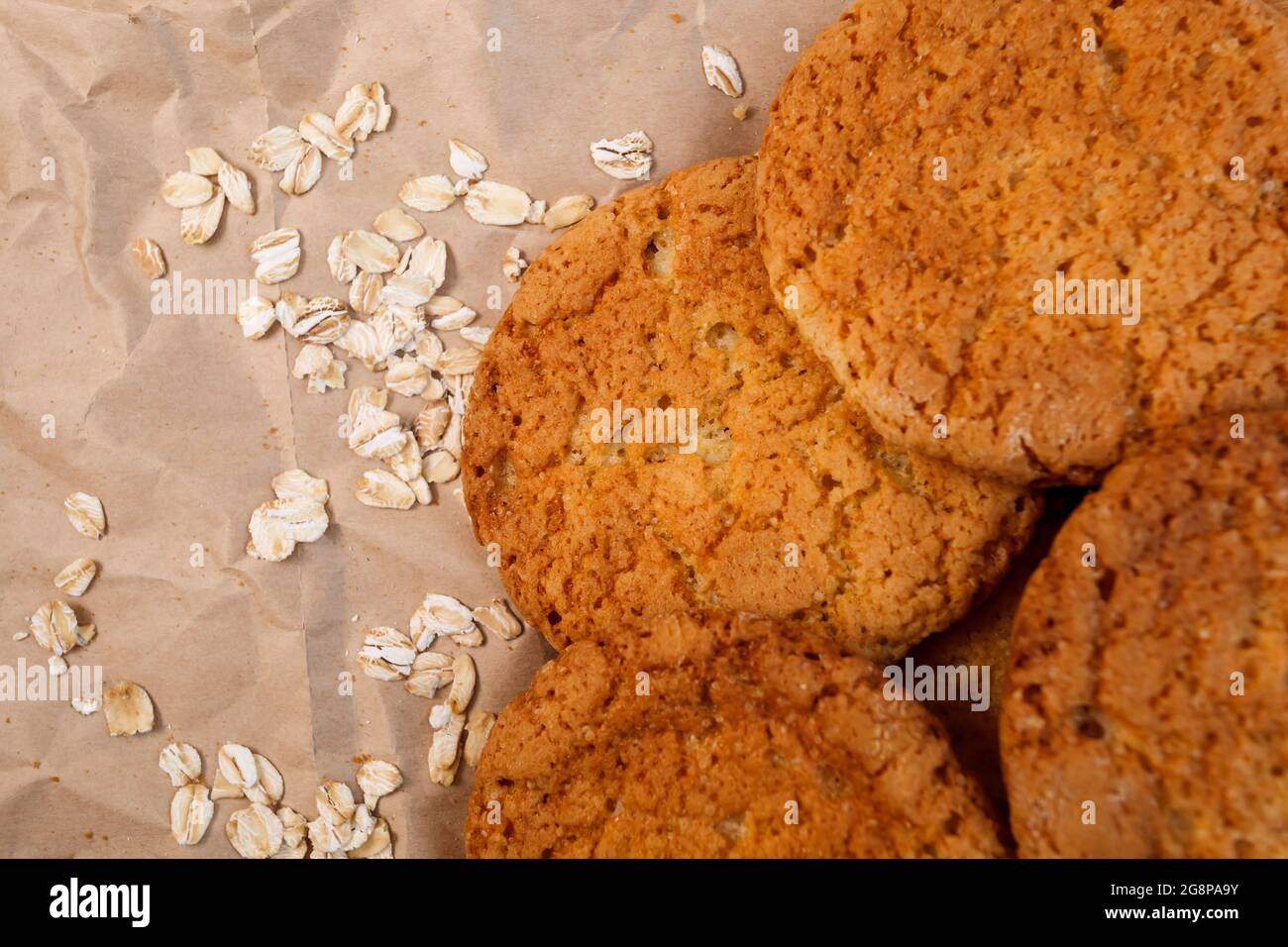 oatmeal cookies and scattered oatmeal on crumpled paper background ...