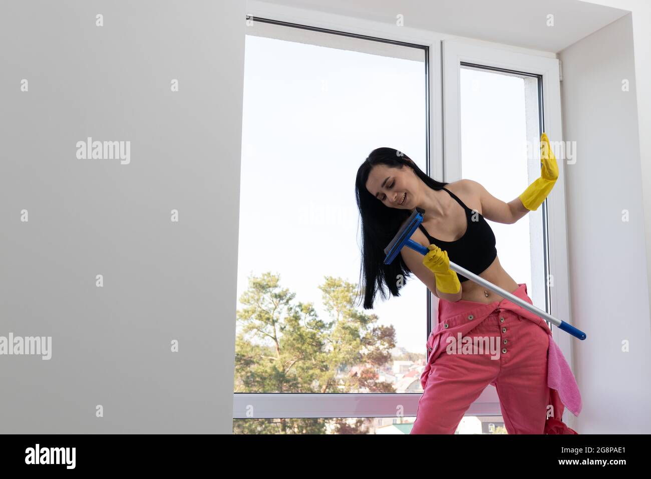 Girl washing windows and sings. Signing young woman Stock Photo - Alamy