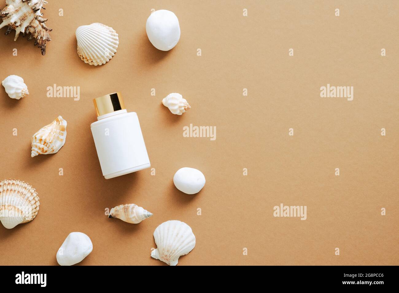 Suntan cream lotion bottle and seashells on sandy color background ...