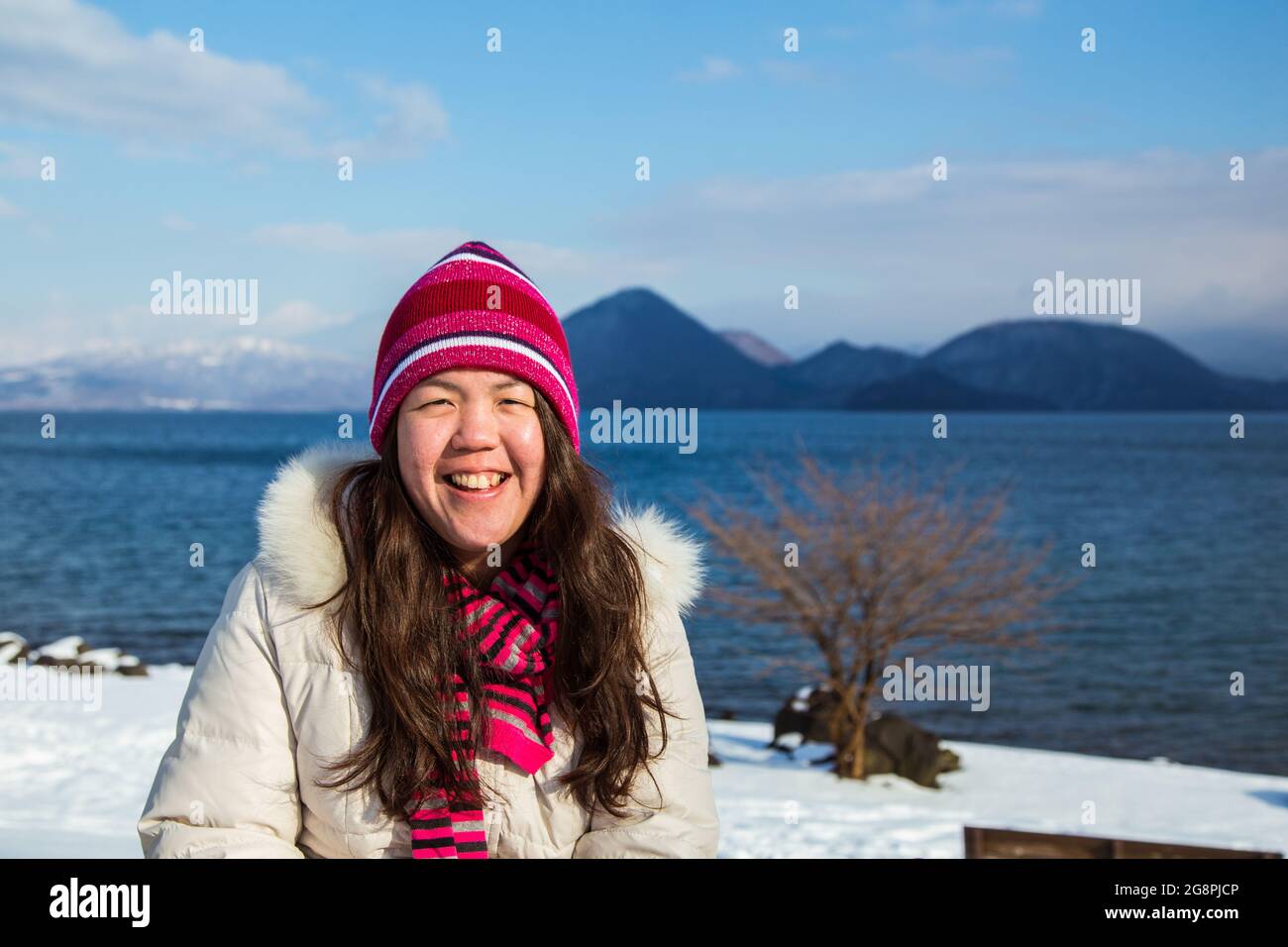 Beautiful and happy young Asia Chinese girl in winter snowy day ...