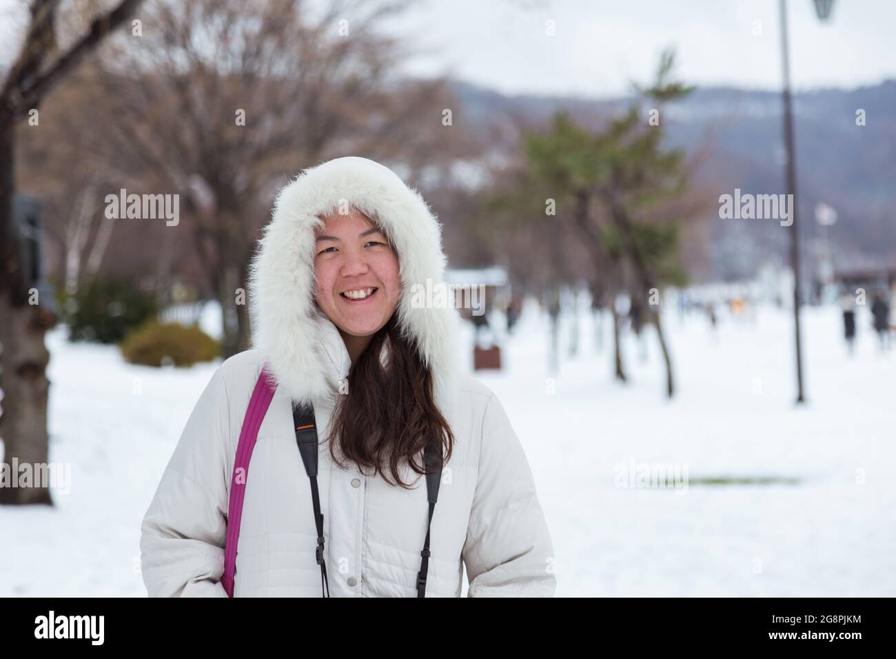 Beautiful and happy young Asia Chinese girl in winter snowy day ...