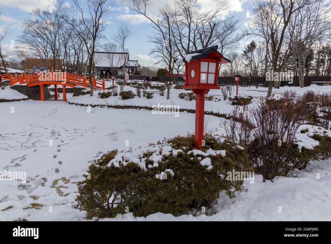 Japanese red bridge with snow in the pond during winter at Noboribetsu ...