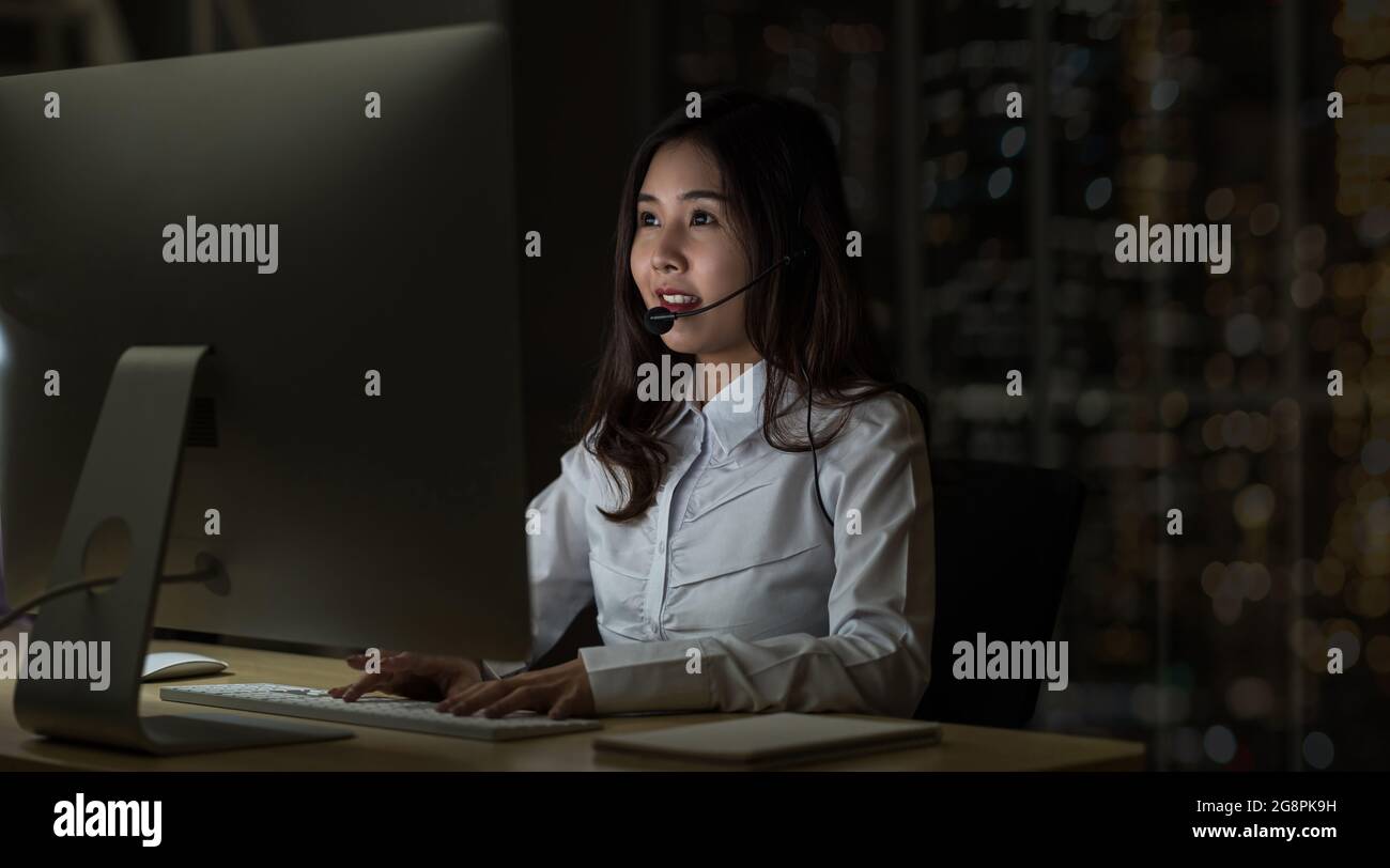 Asian Woman support desk working hard late in night shift at office ...