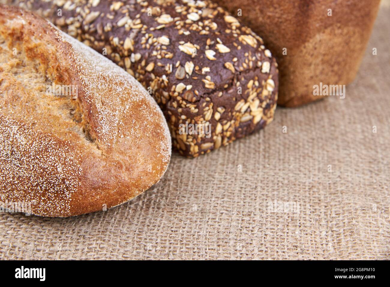 Different types of freshly baked bread on sacking, copy space Stock ...