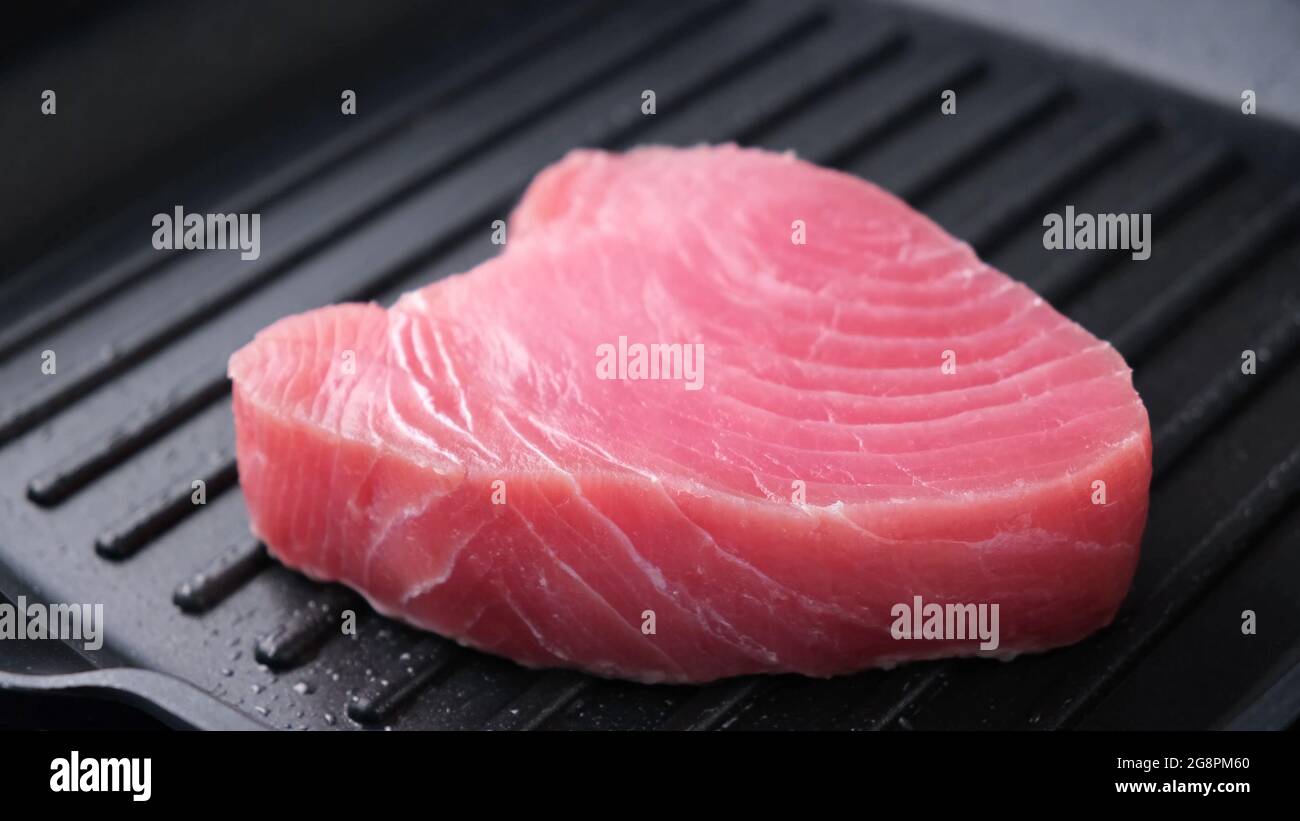 Tuna steak on grill pan. Raw uncooked pink tuna Stock Photo - Alamy