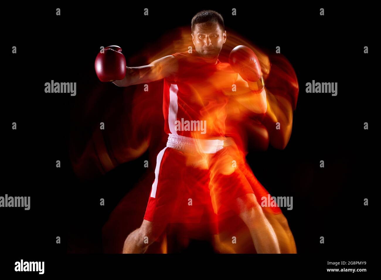 Portrait of professional male boxer in motion, action on black studio ...