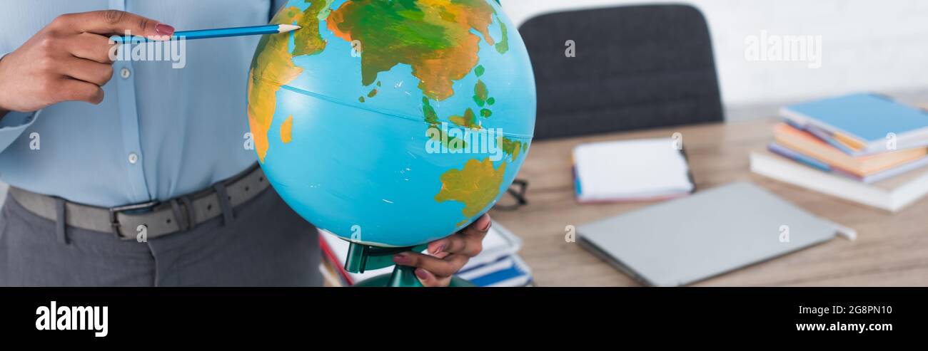 Teacher pointing globe in classroom hi-res stock photography and images ...