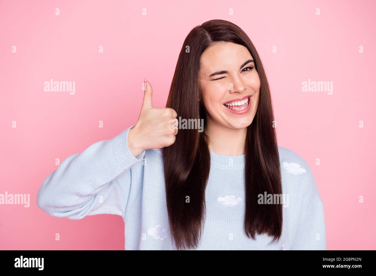 Photo of nice optimistic long hairdo brunette lady show thumb up wink wear blue sweater isolated ...