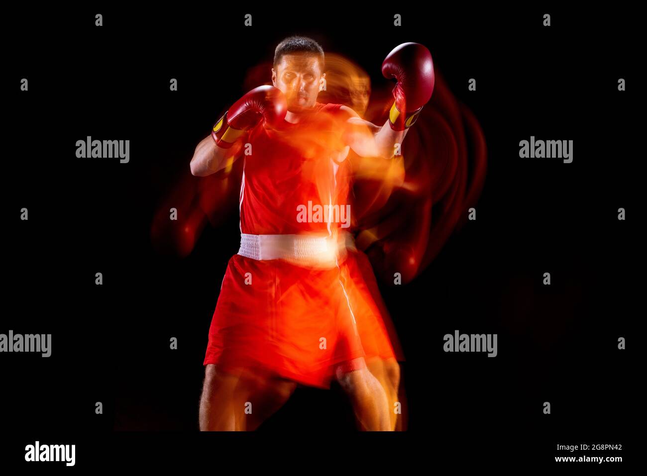 Front view of one professional male boxer in motion, action on black ...