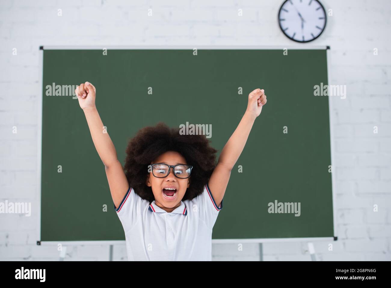Excited african american schoolkid showing yes gesture in classroom ...