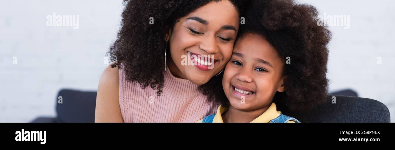 African american mother smiling with closed eyes near child, banner ...