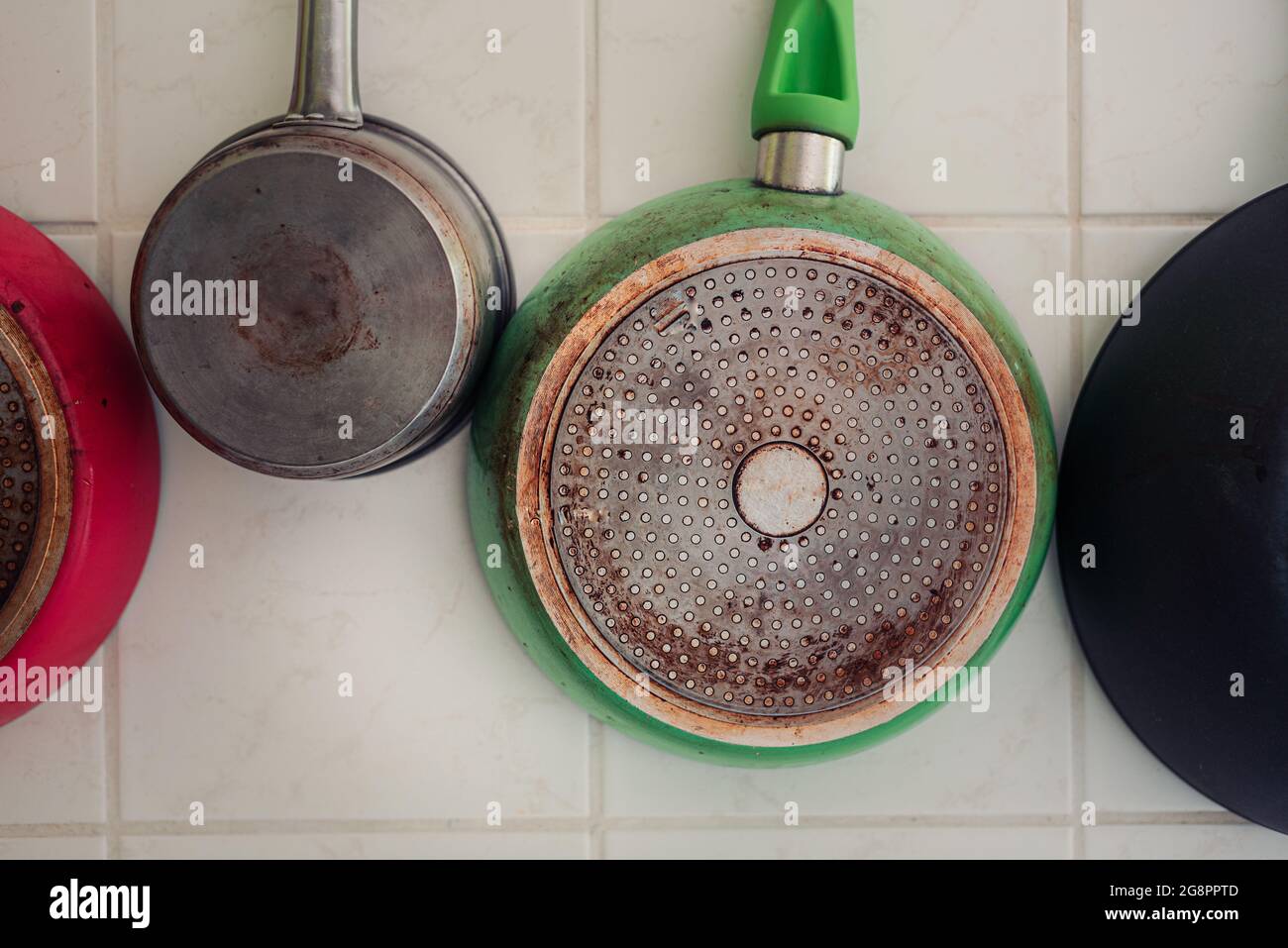 Closeup shot of frying pans of different sizes hung on kitchen wall ...