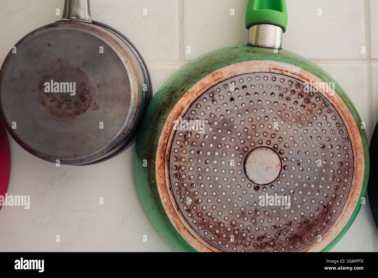 Closeup shot of frying pans of different sizes hung on kitchen wall ...