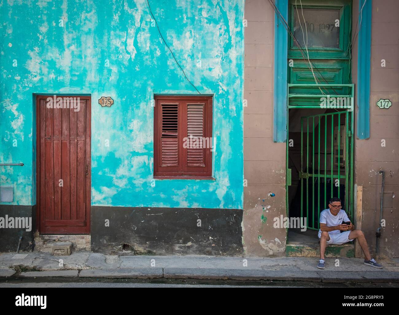 Havana, Cuba, July 2019, man sitting with his mobile phone by the ...