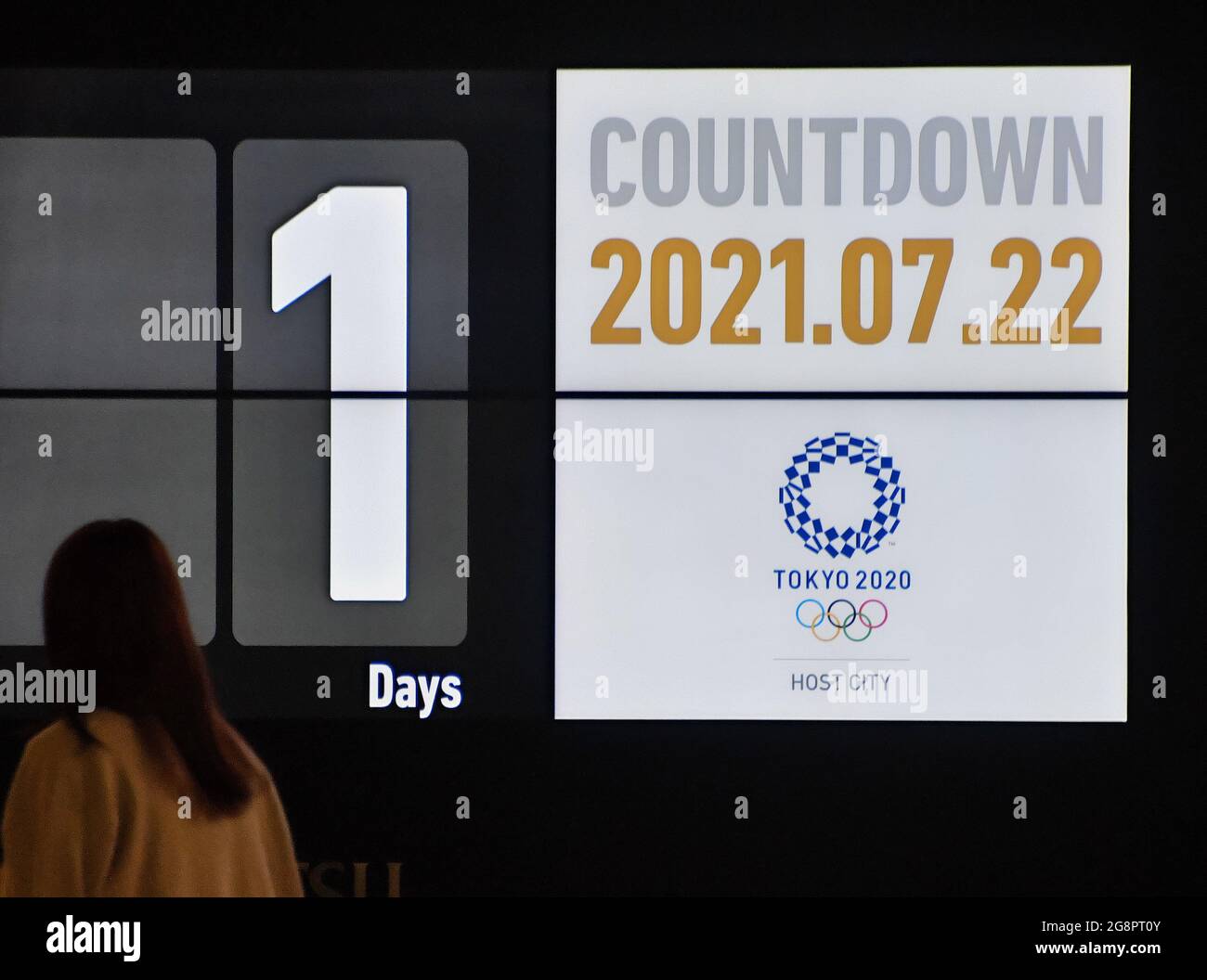 Tokyo, Japan. 22nd July, 2021. Pedestrians walk past the countdown ...