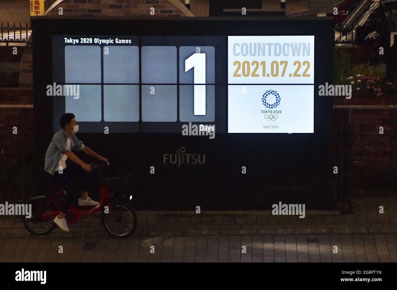 Tokyo, Japan. 22nd July, 2021. Pedestrians walk past the countdown ...