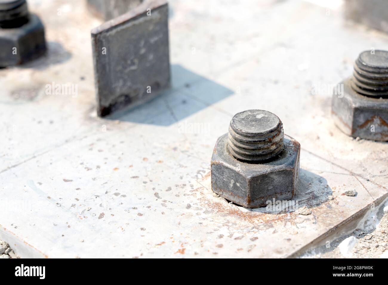 Metal pillar fastened to basement with anchor bolts and nuts ...