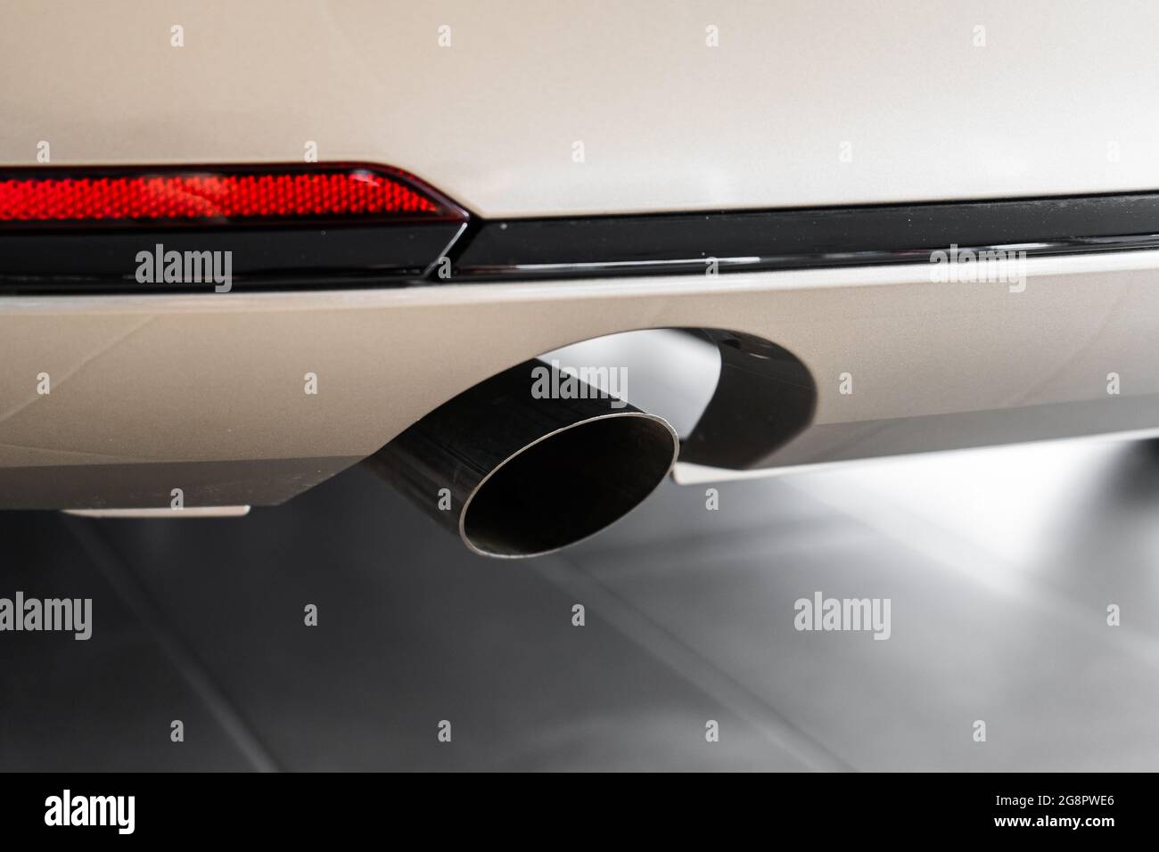 exhaust pipe of a new car. part of the bumper and reflector of a new ...