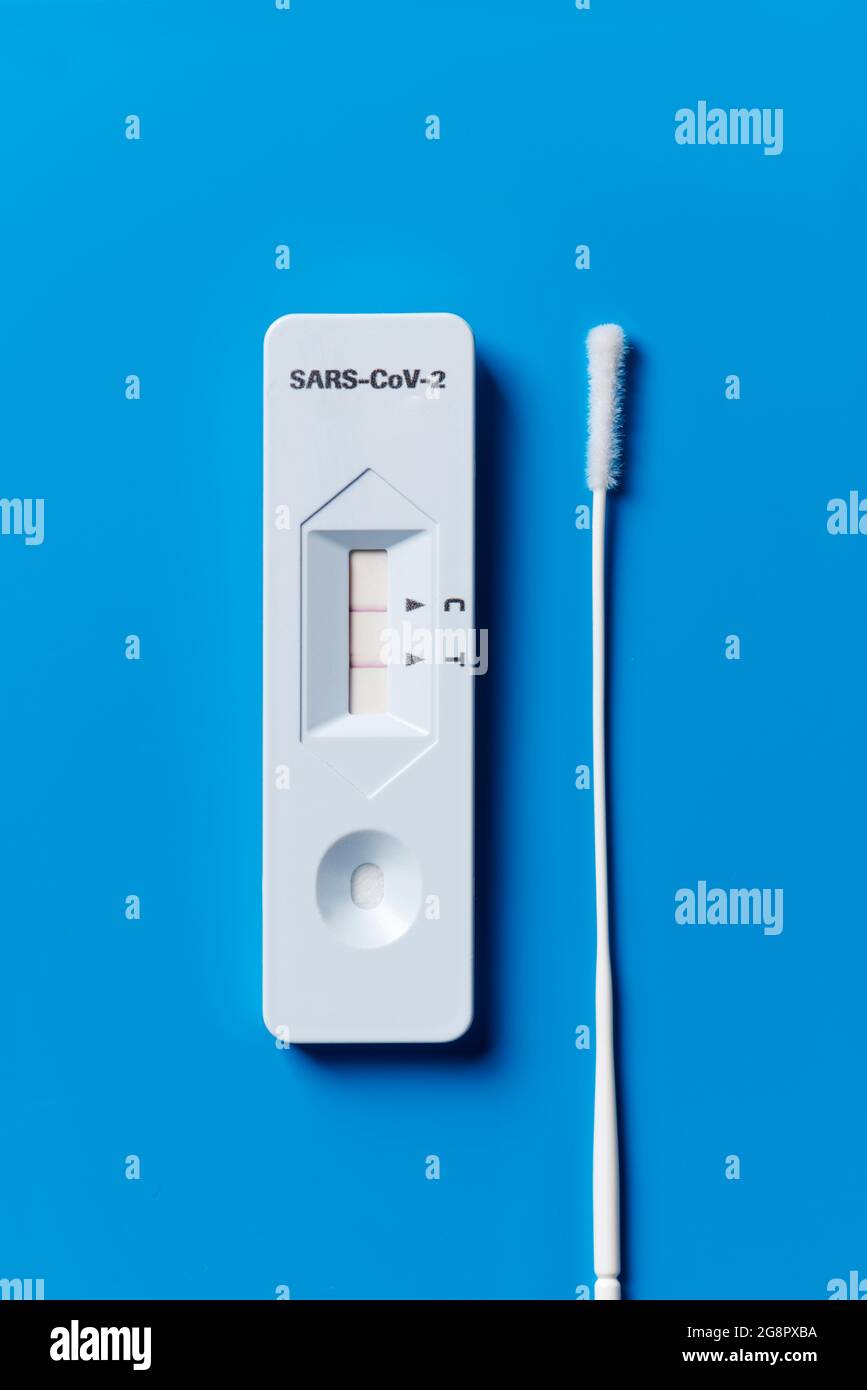 closeup of a nasopharyngeal swab and a covid-19 antigen diagnostic test ...