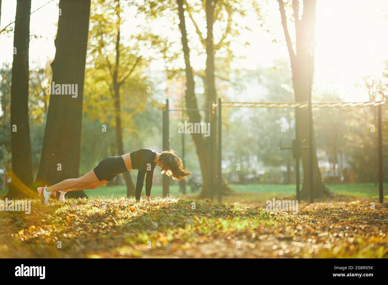 Strong young woman with slender body standing in plank position on ...
