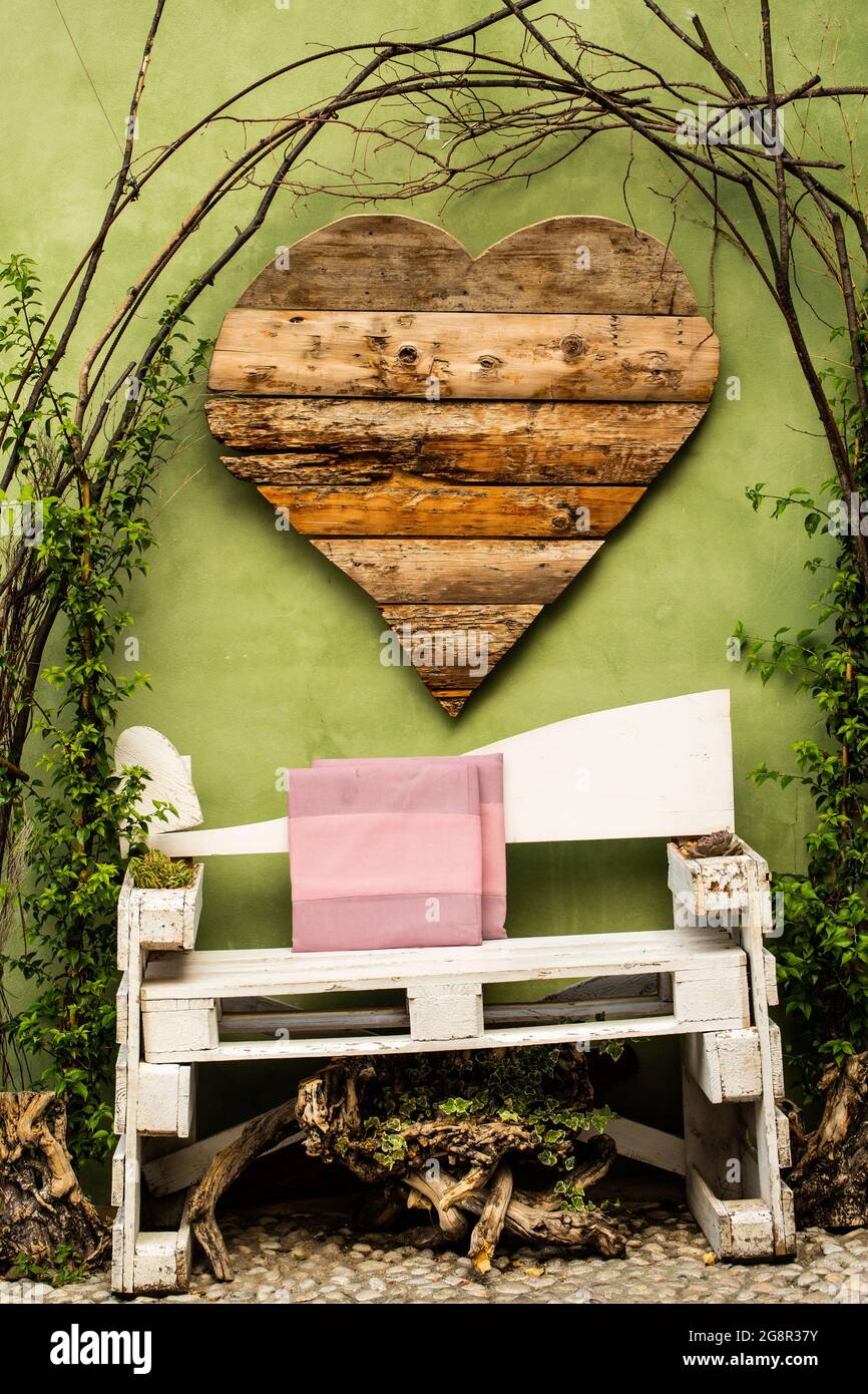 Wooden heart with bench in front of shop Stock Photo - Alamy