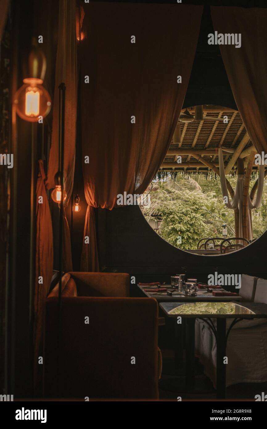 Restaurant interior with tables, candle lights, round window with ...