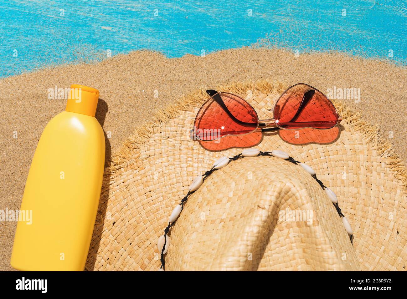 Sunscreen, straw hat and sunglasses on sand, top view Stock Photo - Alamy